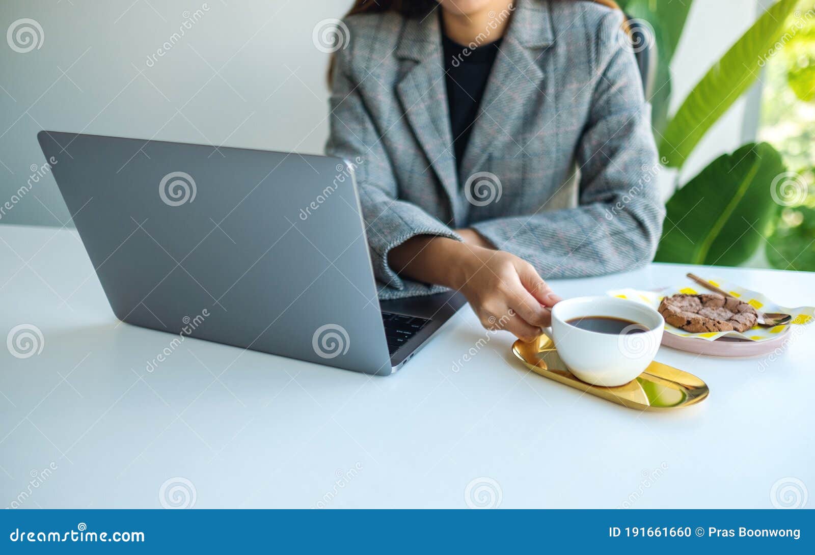 A Business Woman Using and Working on Laptop Computer while Drinking ...