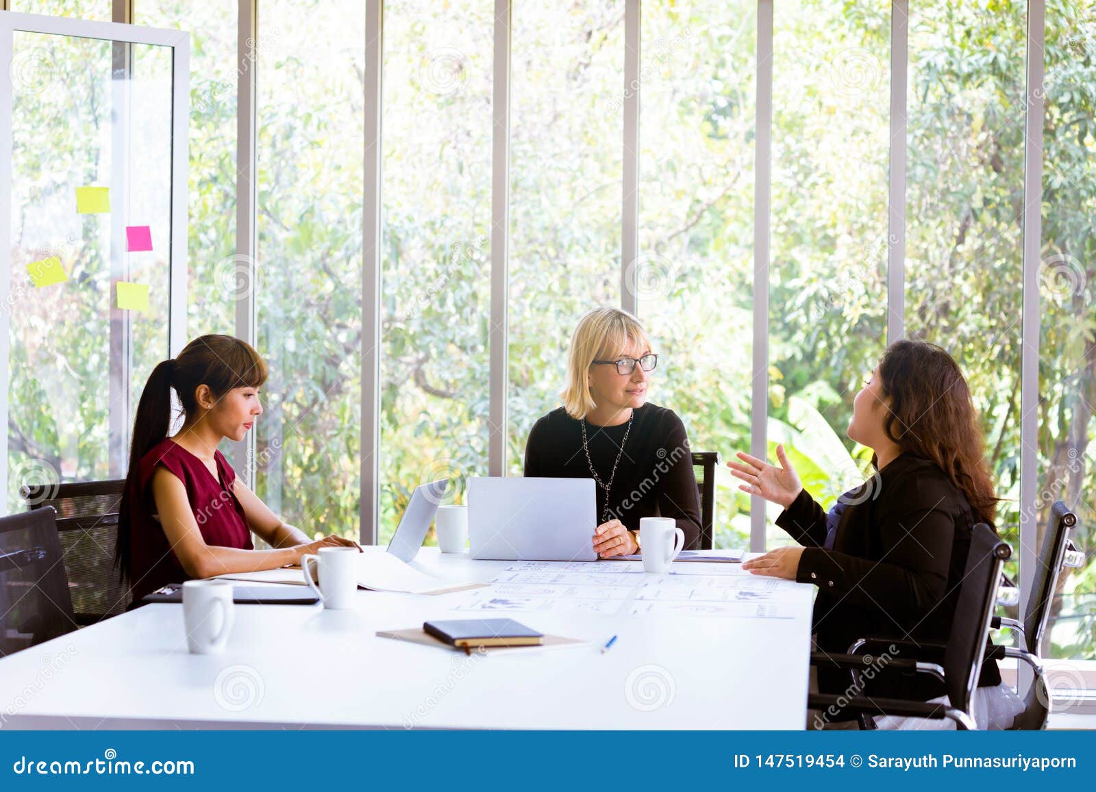 Business Women Discussing at Table in Office Stock Photo - Image of ...
