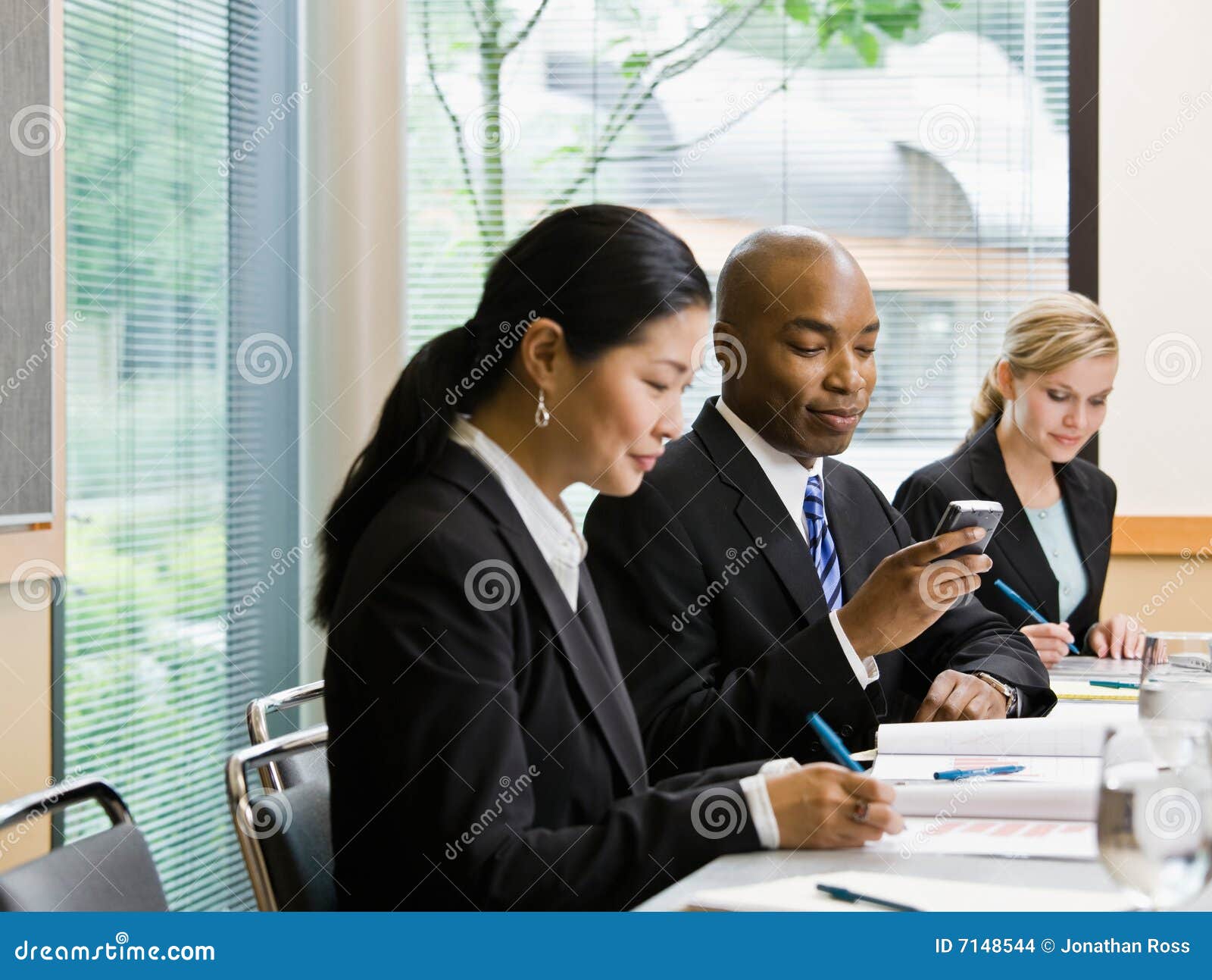 Businessman with Co-workers Text Messaging on Cell Stock Photo - Image ...