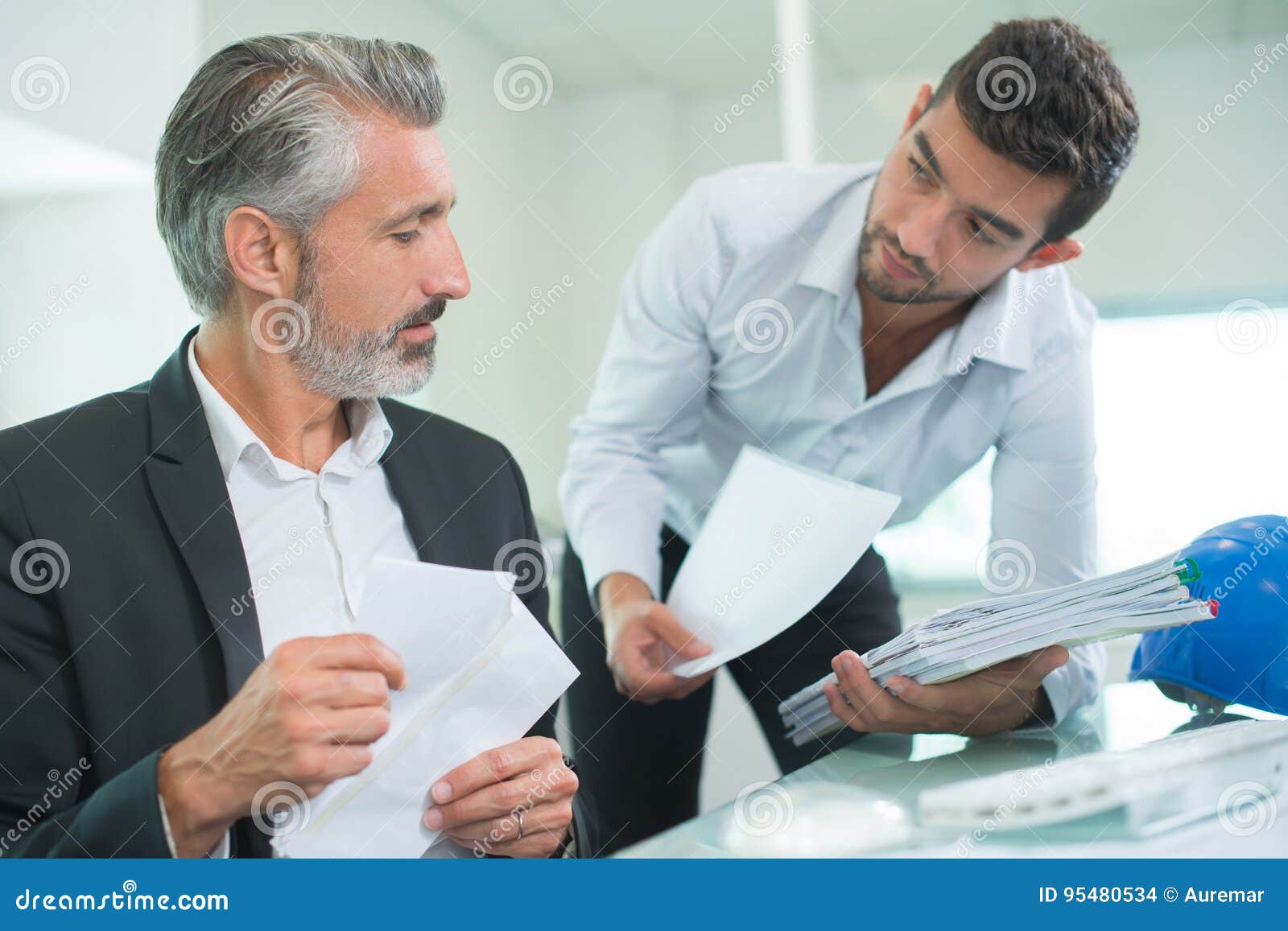 Businessman and Colleague Writing on Paper in Office Stock Photo ...