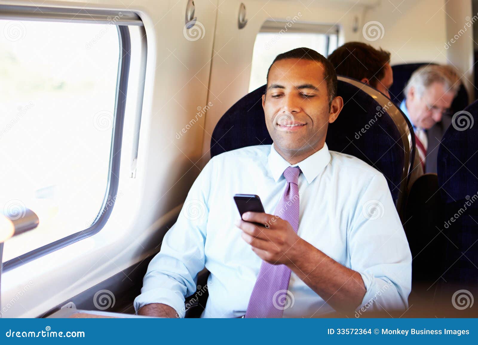 Businessman Commuting To Work on Train Using Mobile Phone Stock Photo ...