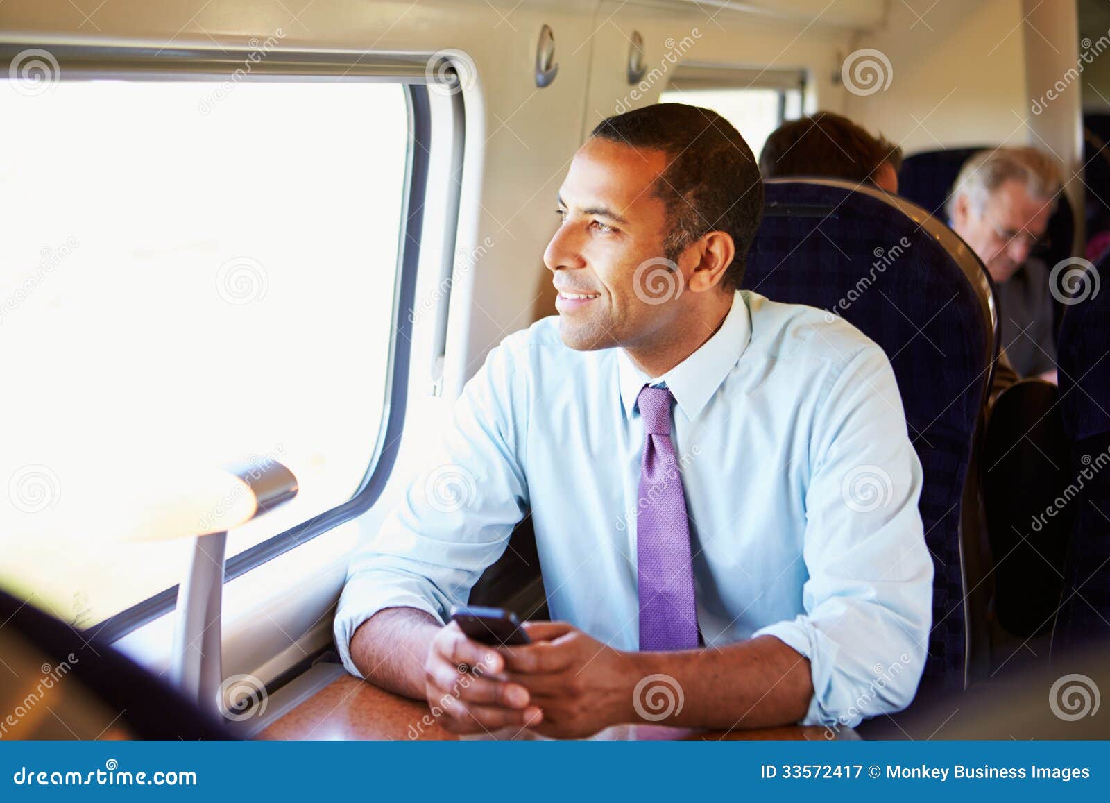 Businessman Commuting To Work on Train Using Mobile Phone Stock Image ...