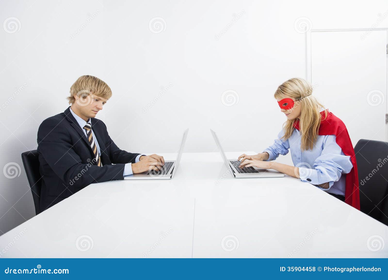 Businessman with Coworker in Superhero Costume Using Laptops at Office ...