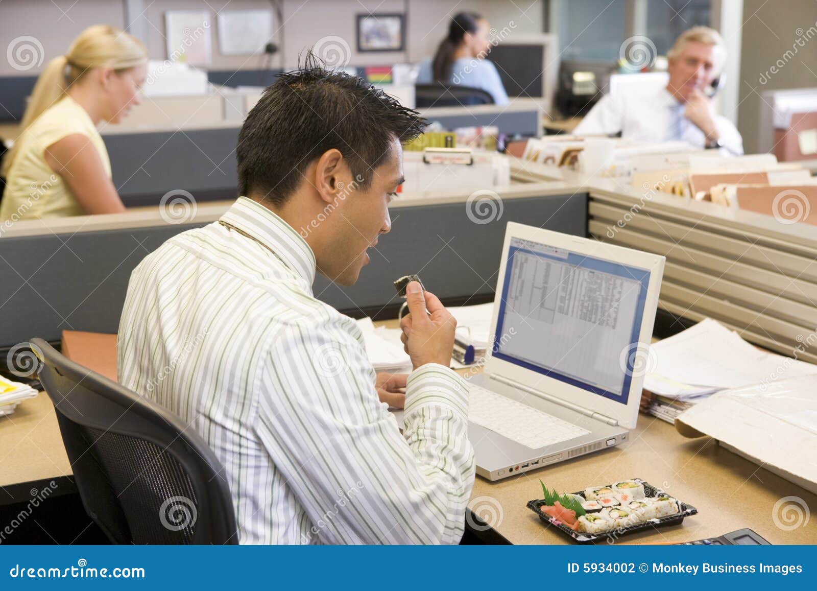 Businessman in Cubicle at Laptop Eating Sushi Stock Photo - Image of ...