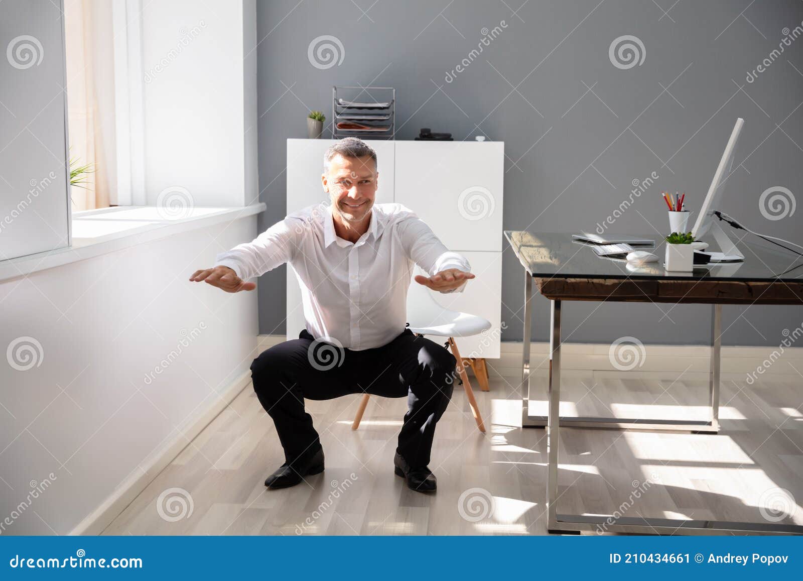 Businessman Doing Squats Exercise in Office Stock Image - Image of ...