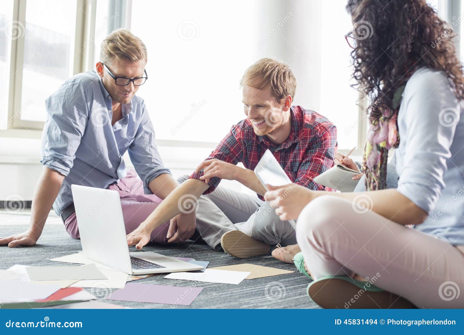 Businessman Explaining Plan on Laptop To Colleagues at Creative Office ...