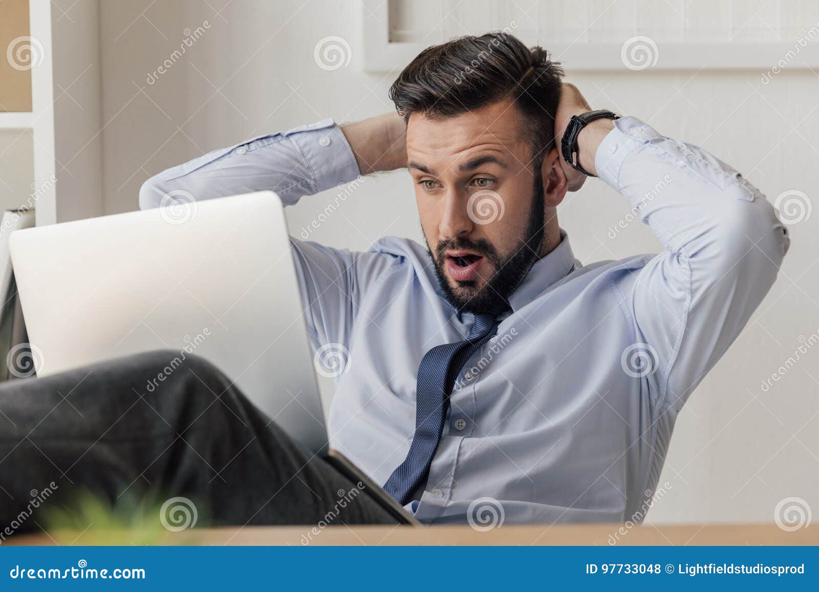 Businessman with Hands on Head Working on Laptop while Sitting at ...