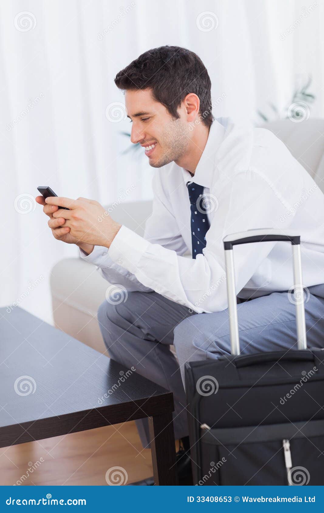 Businessman with His Suitcase Using Mobile Phone Smiling Stock Image ...
