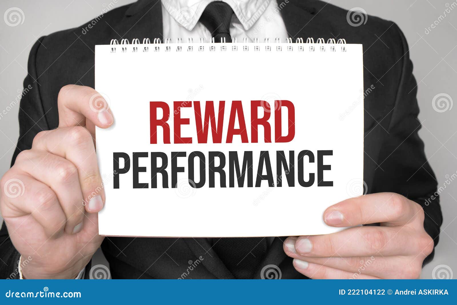 Businessman Holding a Notepad with Text REWARD PERFORMANCE Stock Photo ...