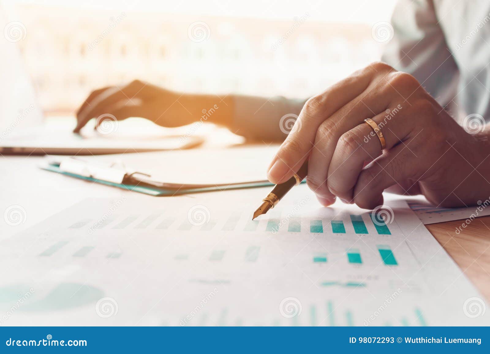 Businessman Holding Pen and Pointing Chart Report Paper on Desk Stock ...