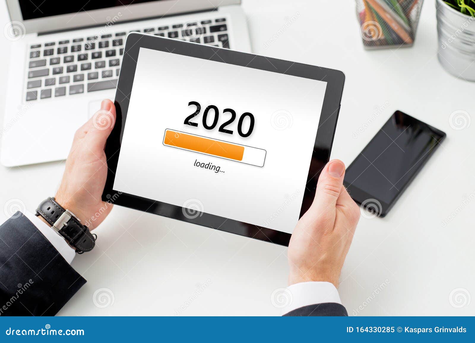 Businessman Holding Tablet with New Year of 2020 Loading on the Screen ...