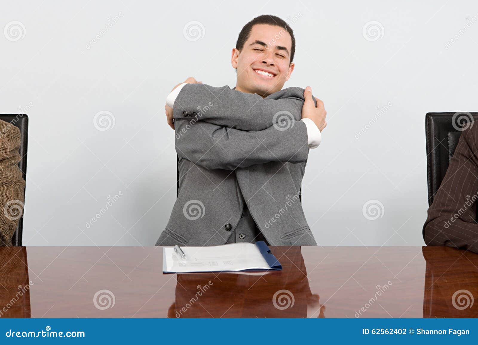 Businessman Hugging Himself Stock Photo - Image of indoors, closed ...