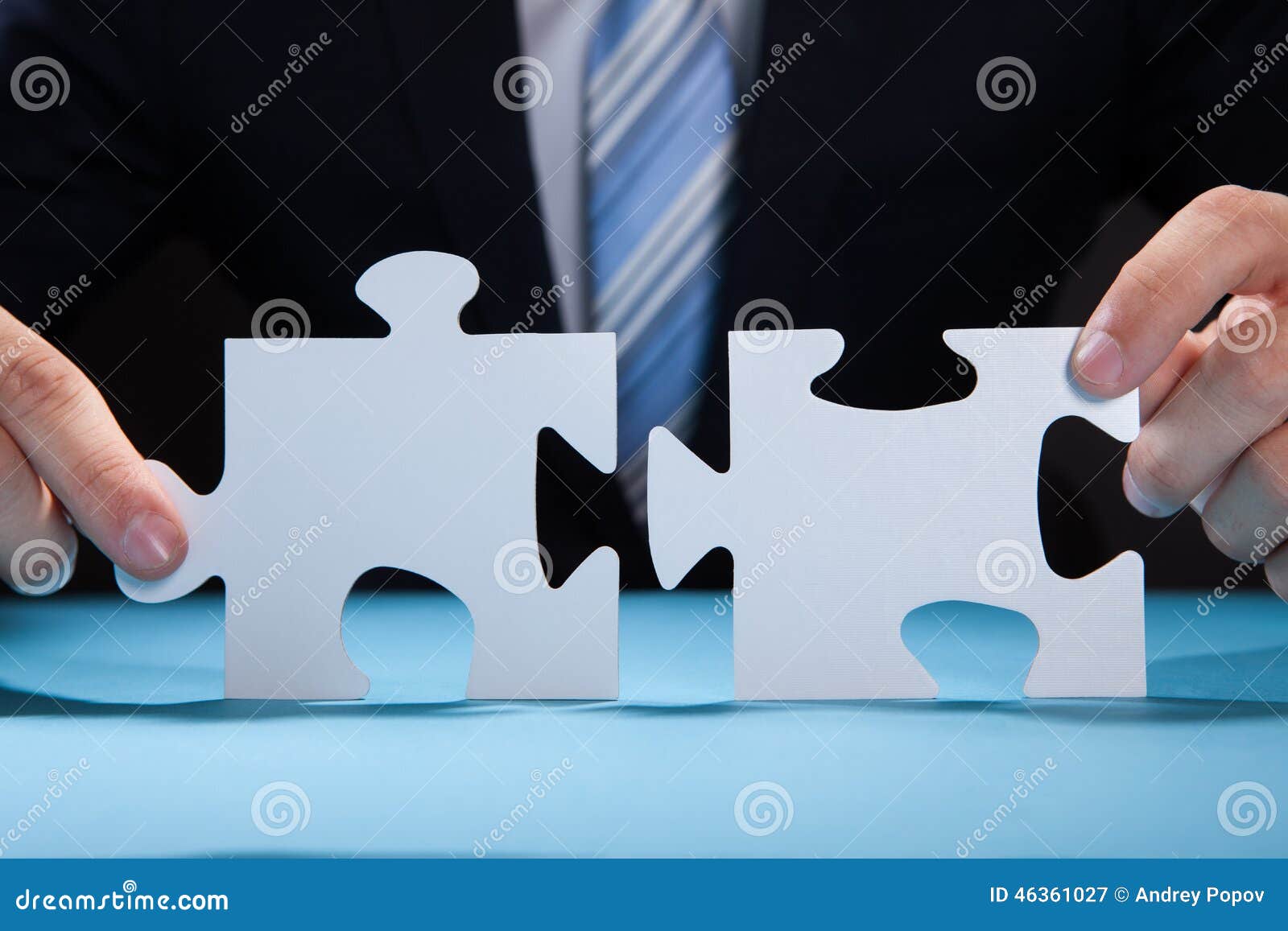 Businessman Joining Puzzle Pieces at Desk Stock Image - Image of focus ...