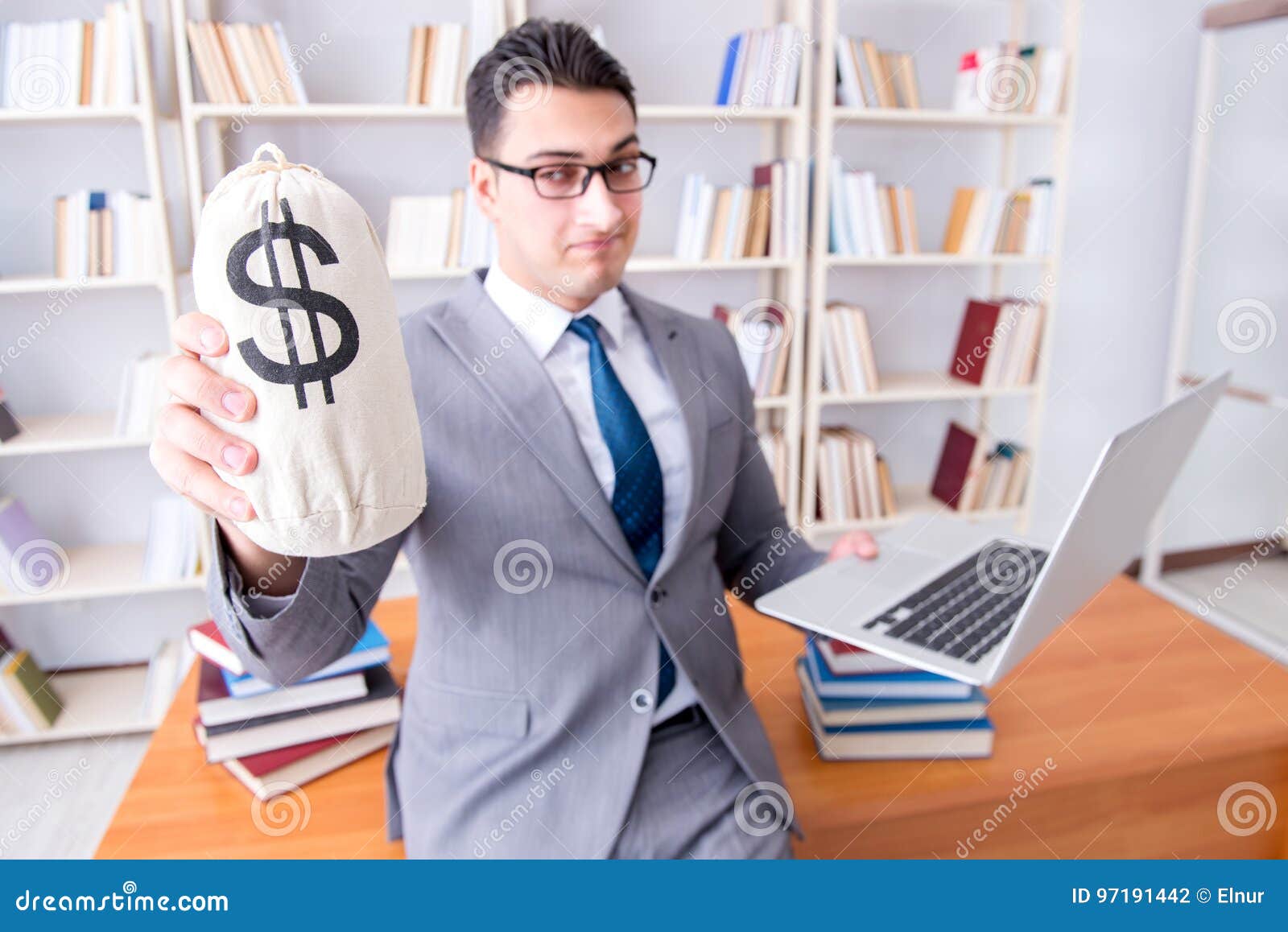 The Businessman in Library with a Money Sack and a Laptop Stock Photo ...