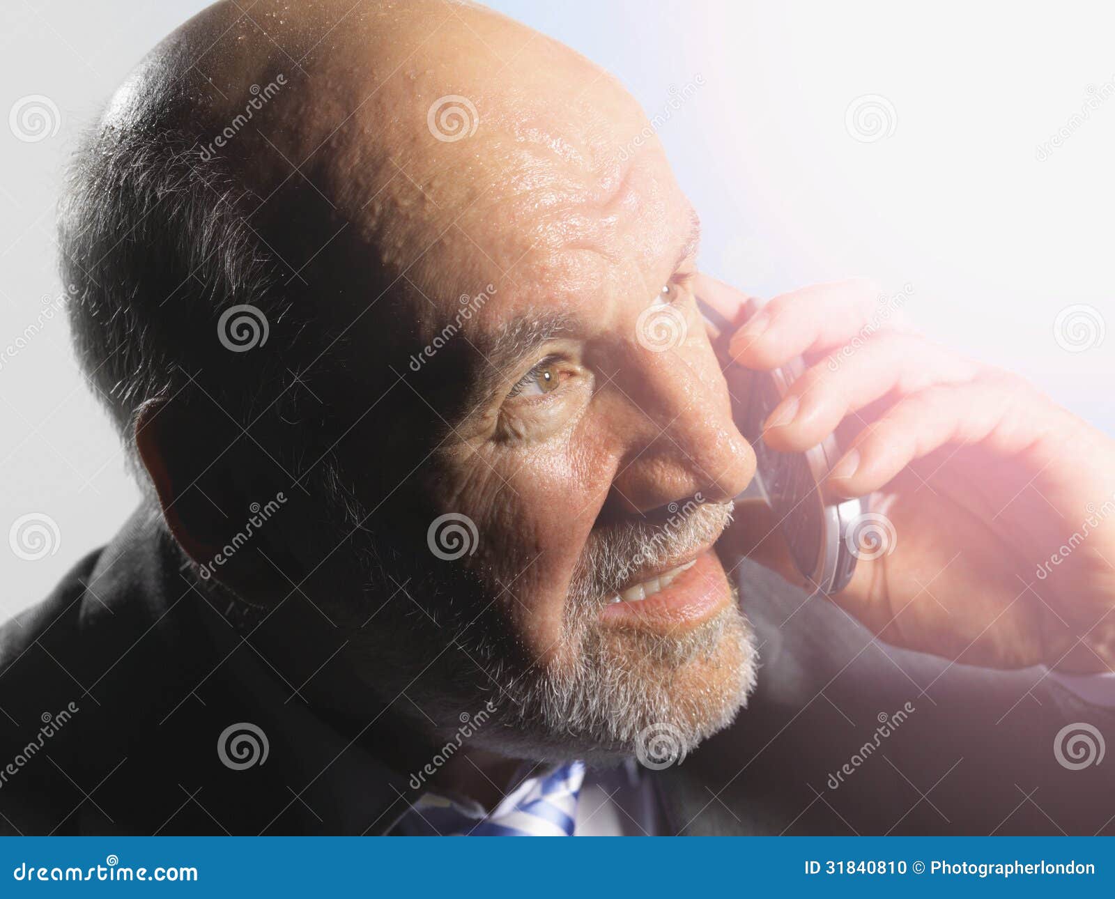 Businessman Looking into Bright Light while Using Cellphone Stock Photo ...