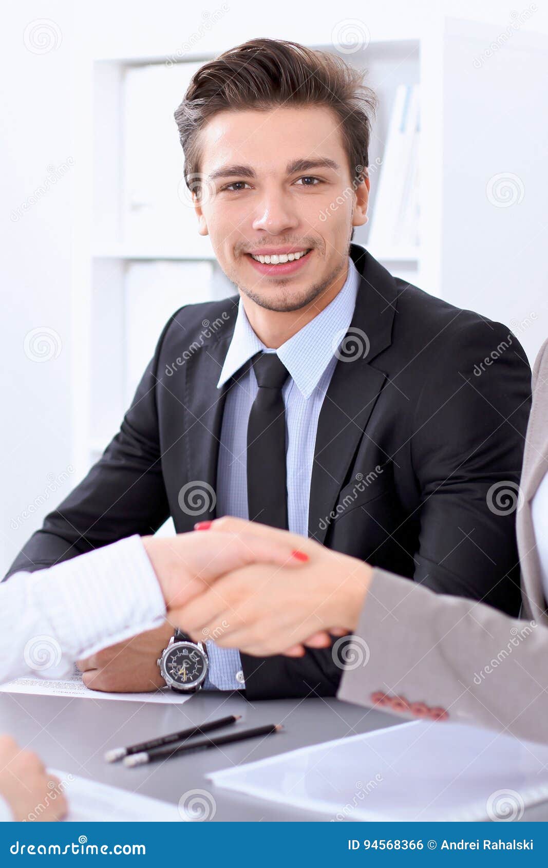 Businessman Looking at Camera while Partners Shaking Hands at Meeting ...