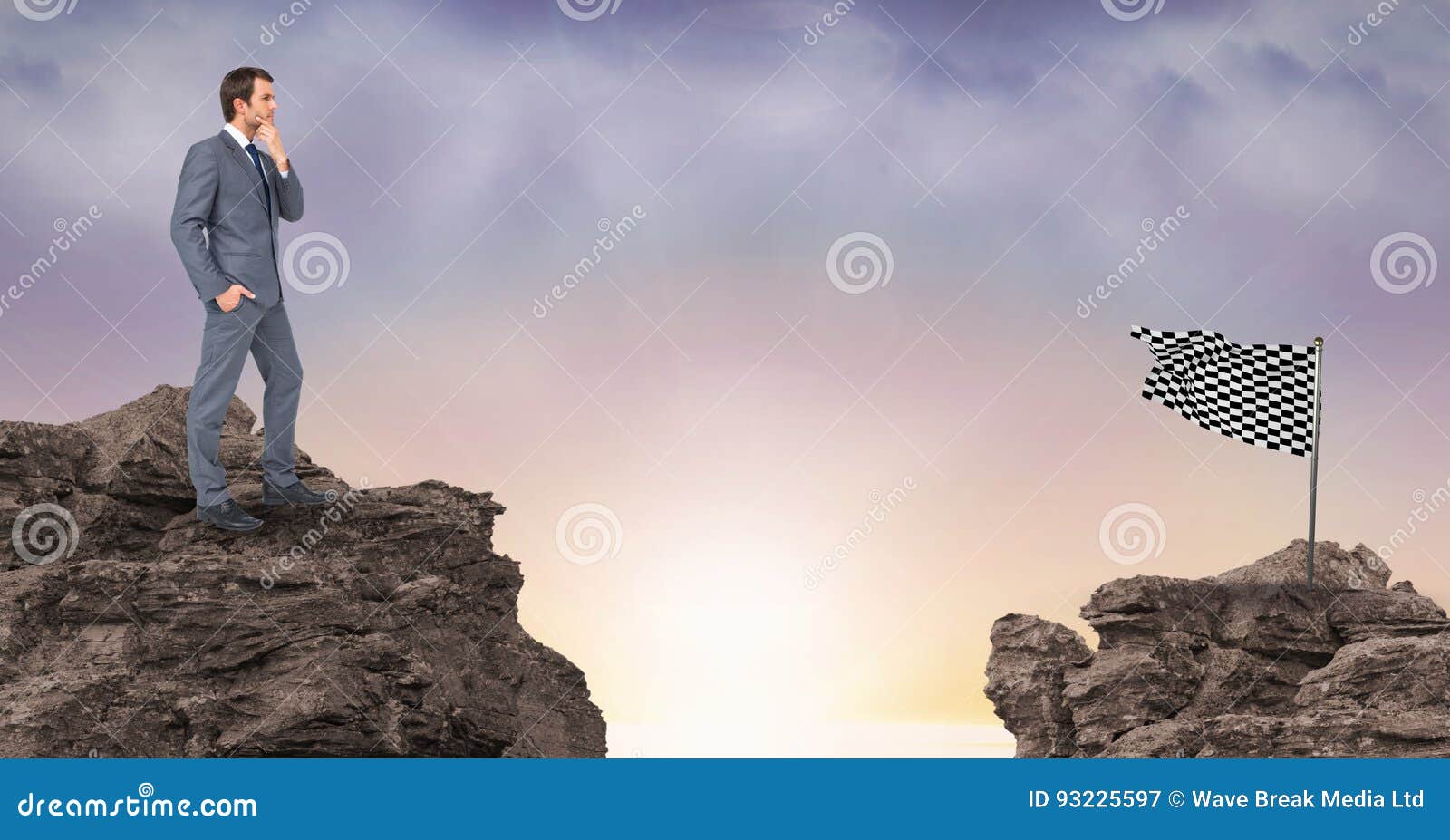 Businessman Looking at Checkered Flag while Standing on Rocks Against ...