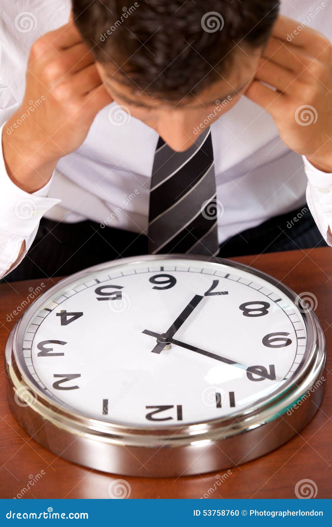Businessman Looking at Clock in Office with Head in Hands Stock Photo ...