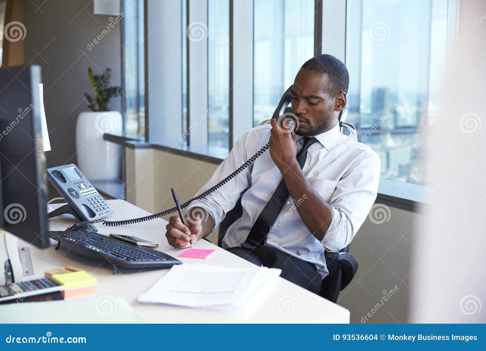 Businessman Making Phone Call Sitting at Desk in Office Stock Photo ...