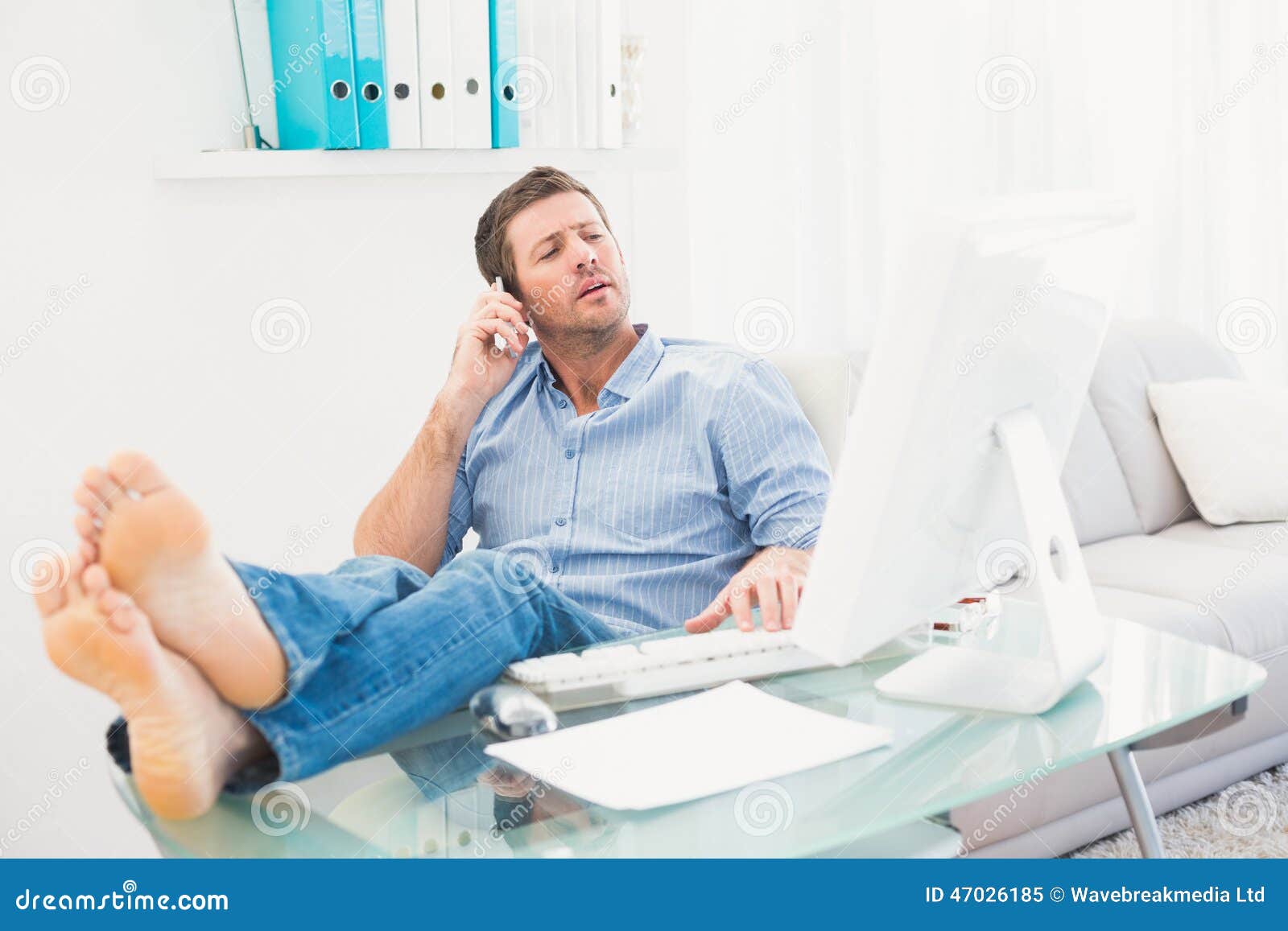 Businessman on the Phone Using His Computer with His Feet Up Stock ...