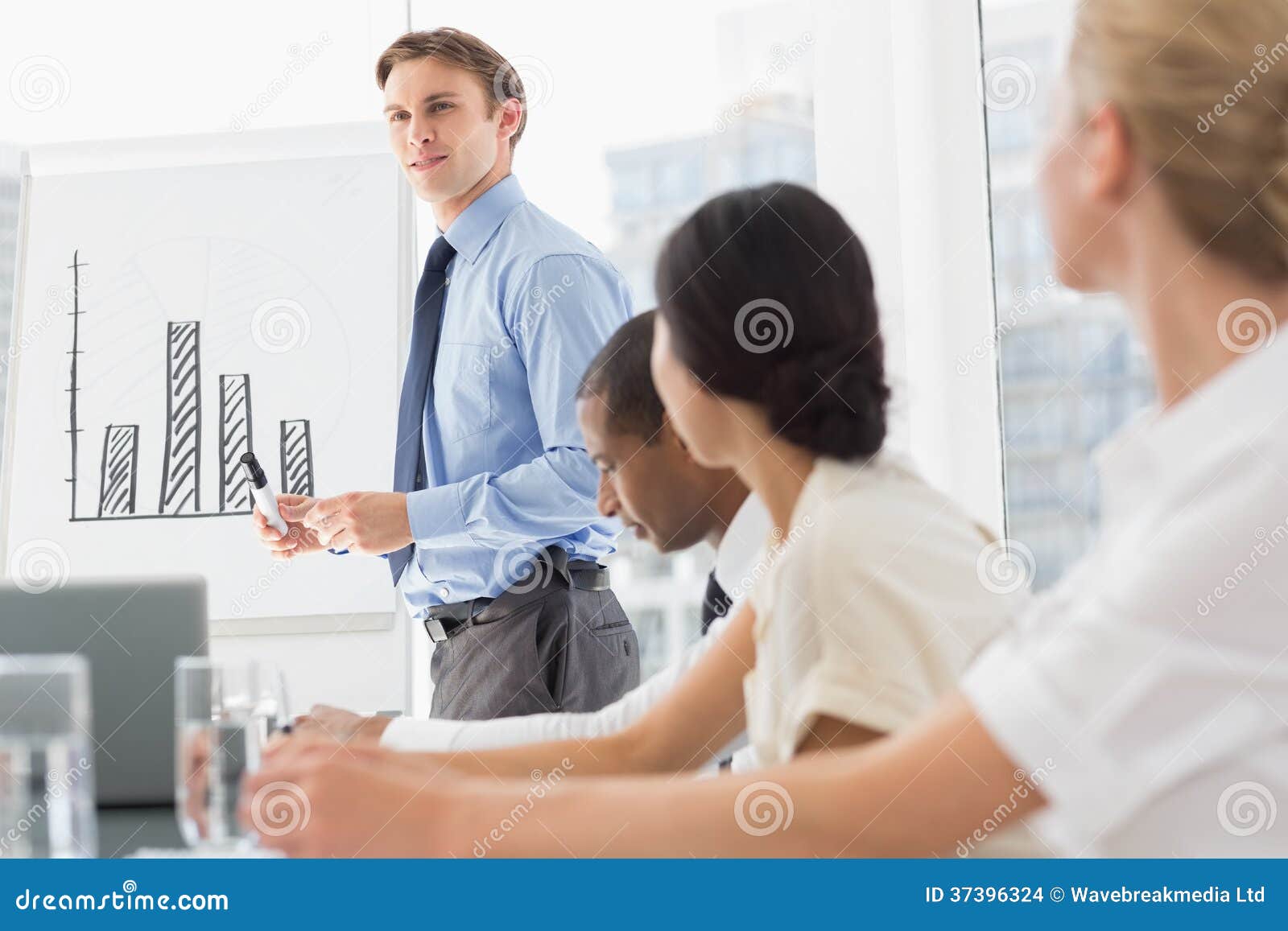 Businessman Presenting Bar Chart To Colleagues Stock Photo - Image of ...
