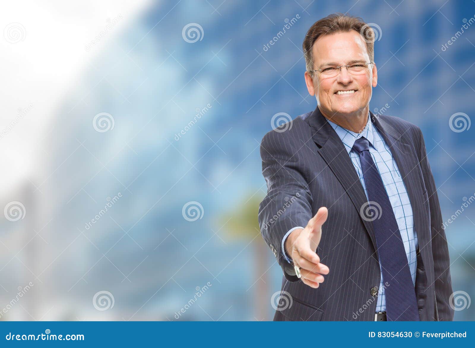 Businessman Reaching for Hand Shake in Front of Building Stock Photo ...