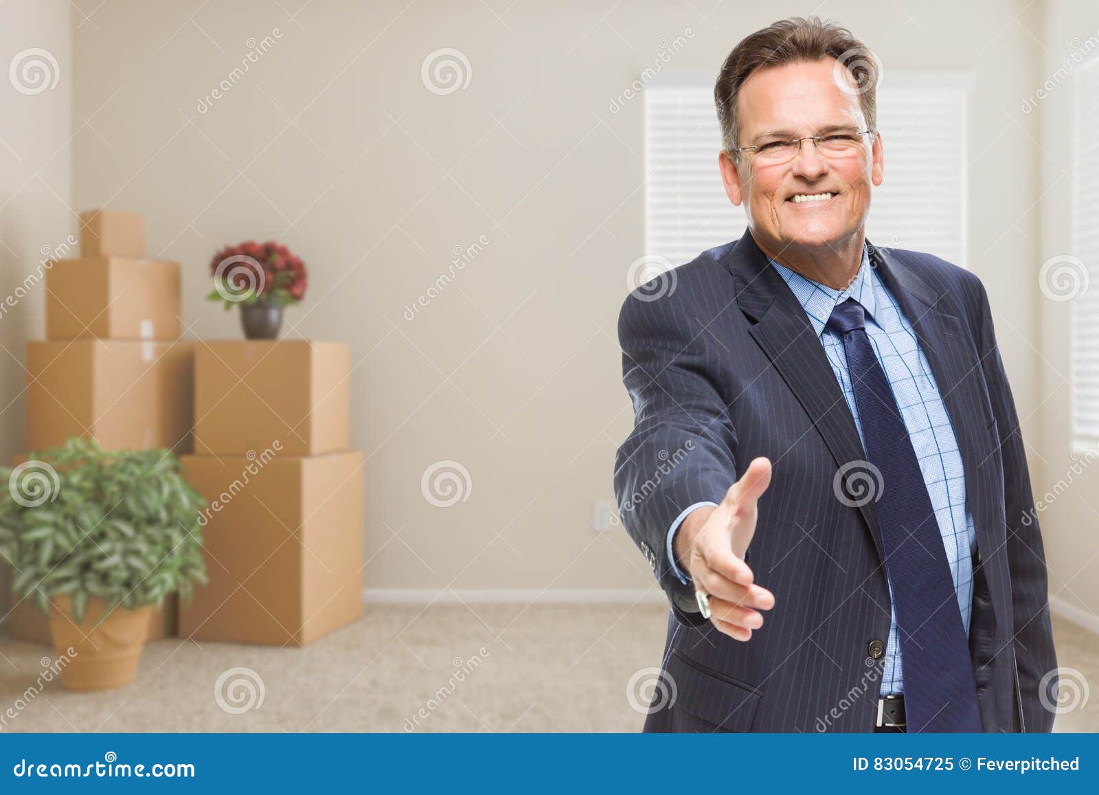 Businessman Reaching for Hand Shake in Room with Packed Boxes Stock ...