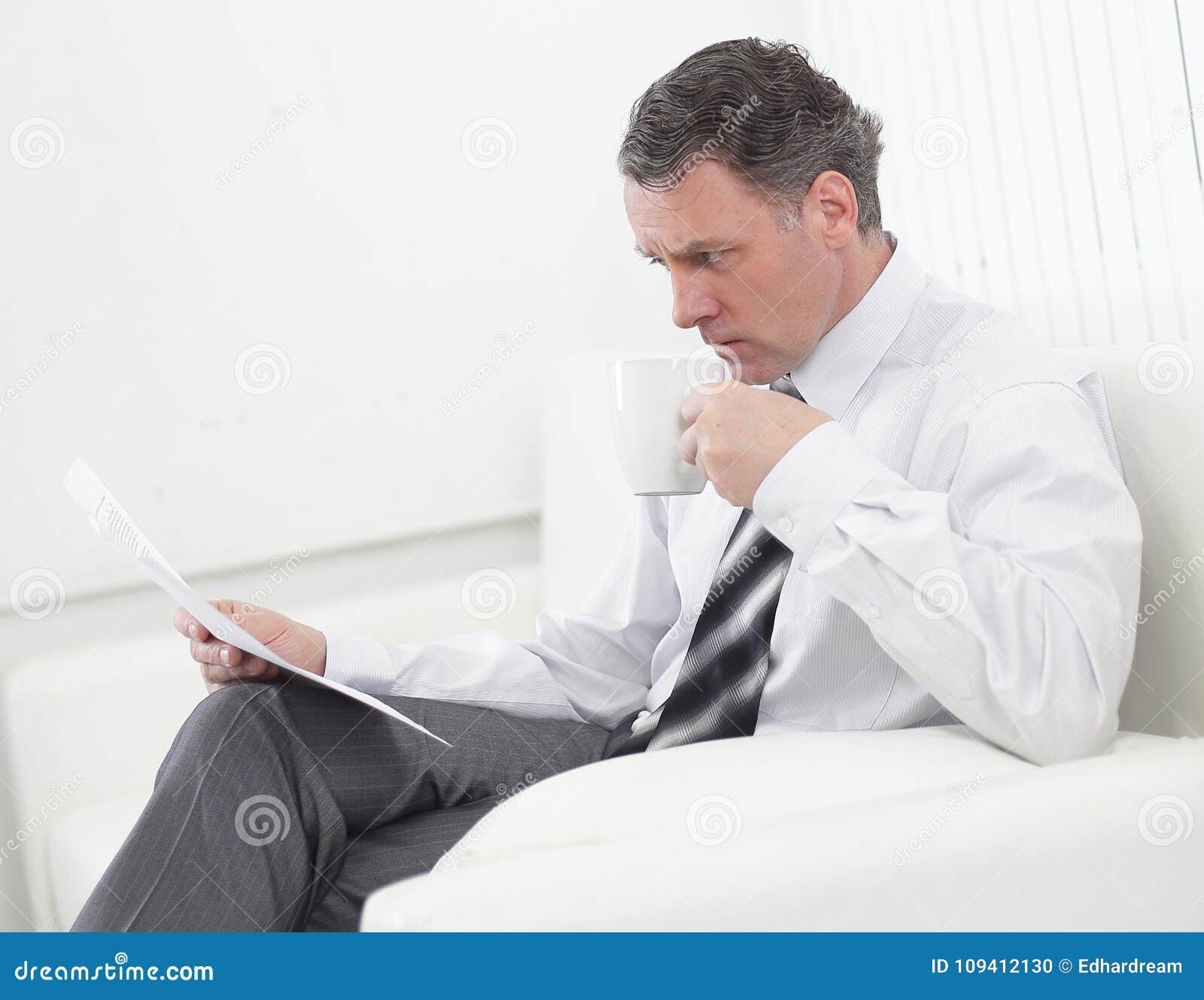 Businessman Reading a Document while Sitting in a Chair in the Hotel ... Businessman Reading a Document while Sitting in a Chair in the Hotel ...