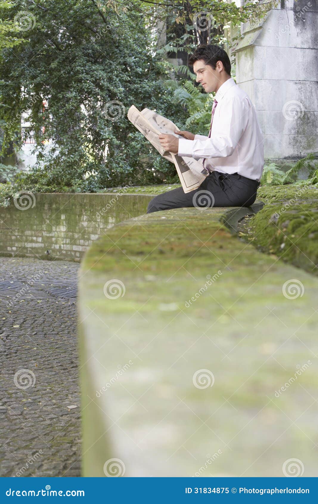 Businessman Reading Newspaper on Wall in Park Stock Image - Image of ...