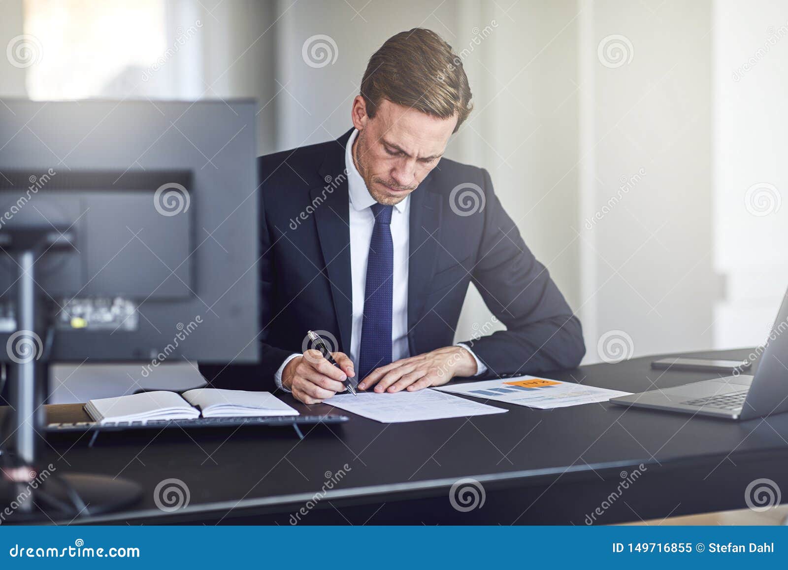 Businessman Reading through Paperwork at His Office Desk Stock Image ...