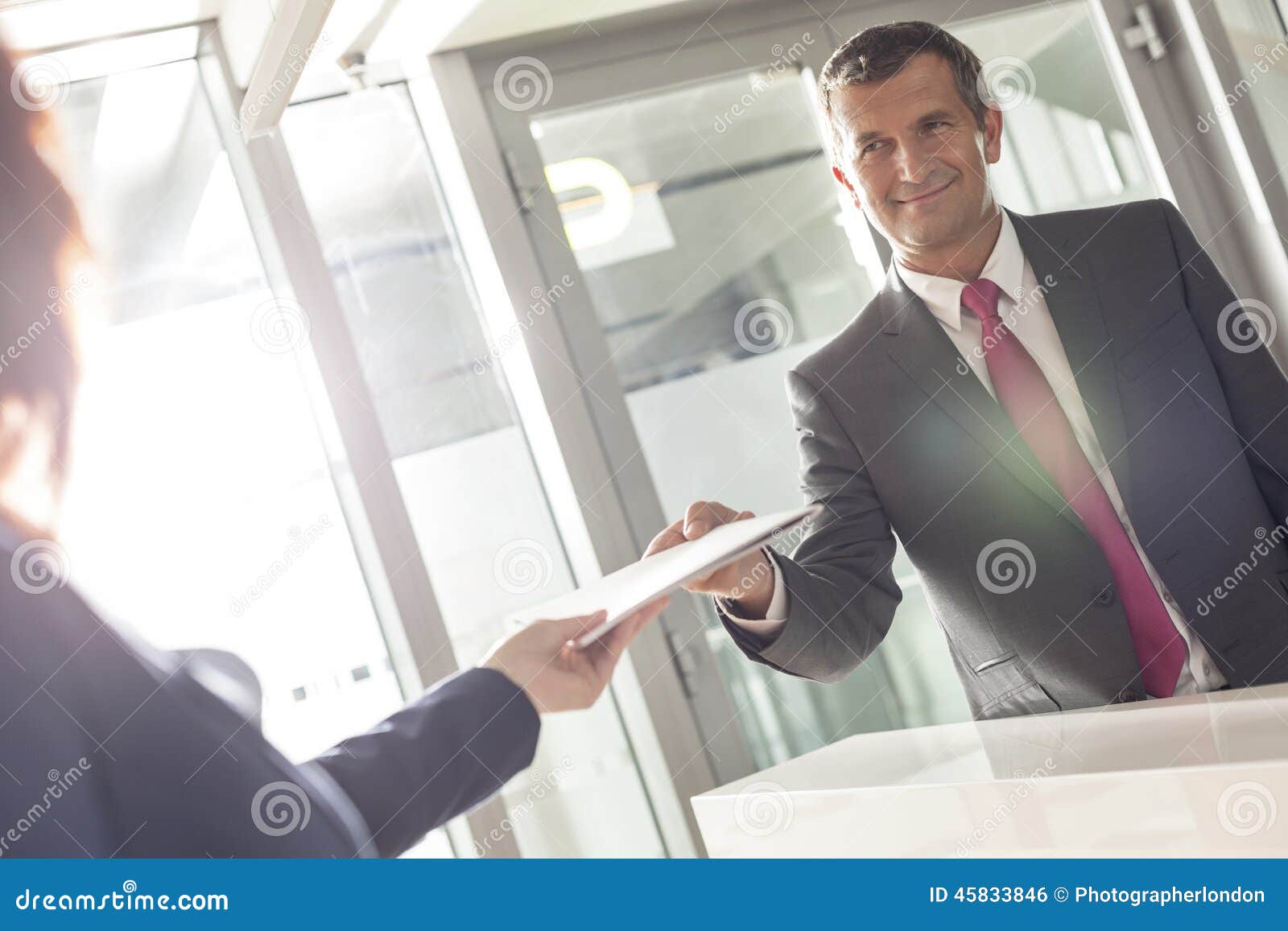Businessman Receiving Document from Receptionist in Office Stock Photo ...