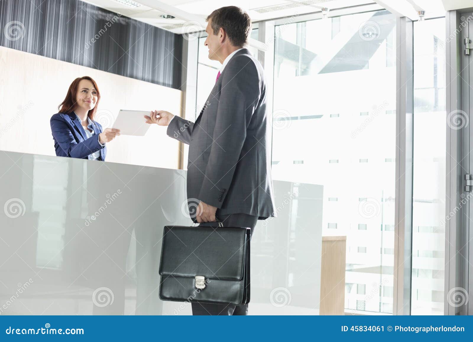 Businessman Receiving Document from Receptionist in Office Stock Image ...
