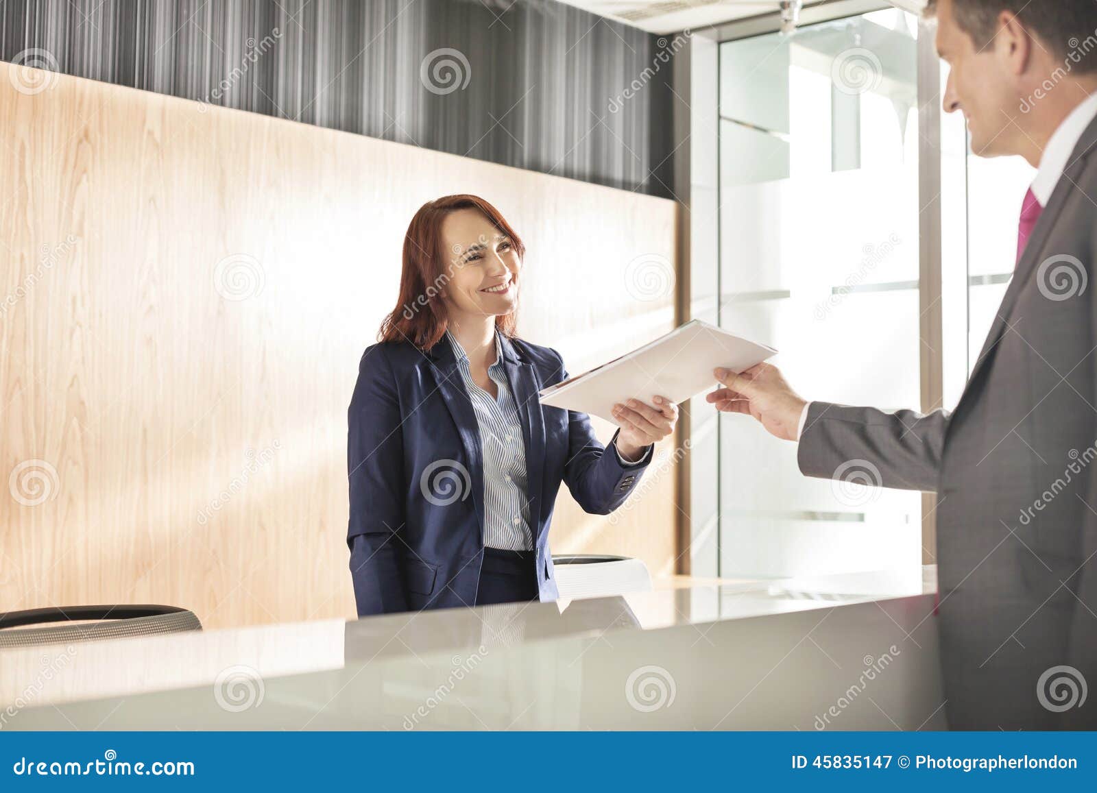 Businessman Receiving Document from Receptionist in Office Stock Image ...