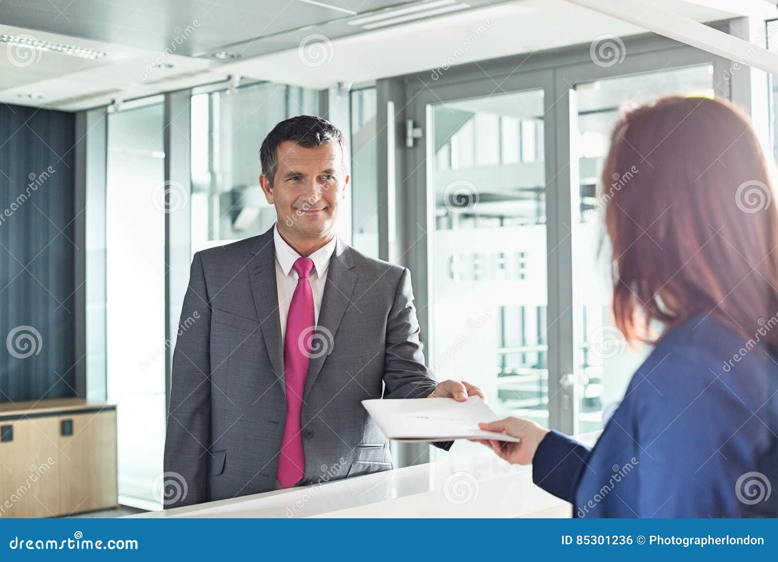 Businessman Receiving Document from Receptionist in Office Stock Photo ...