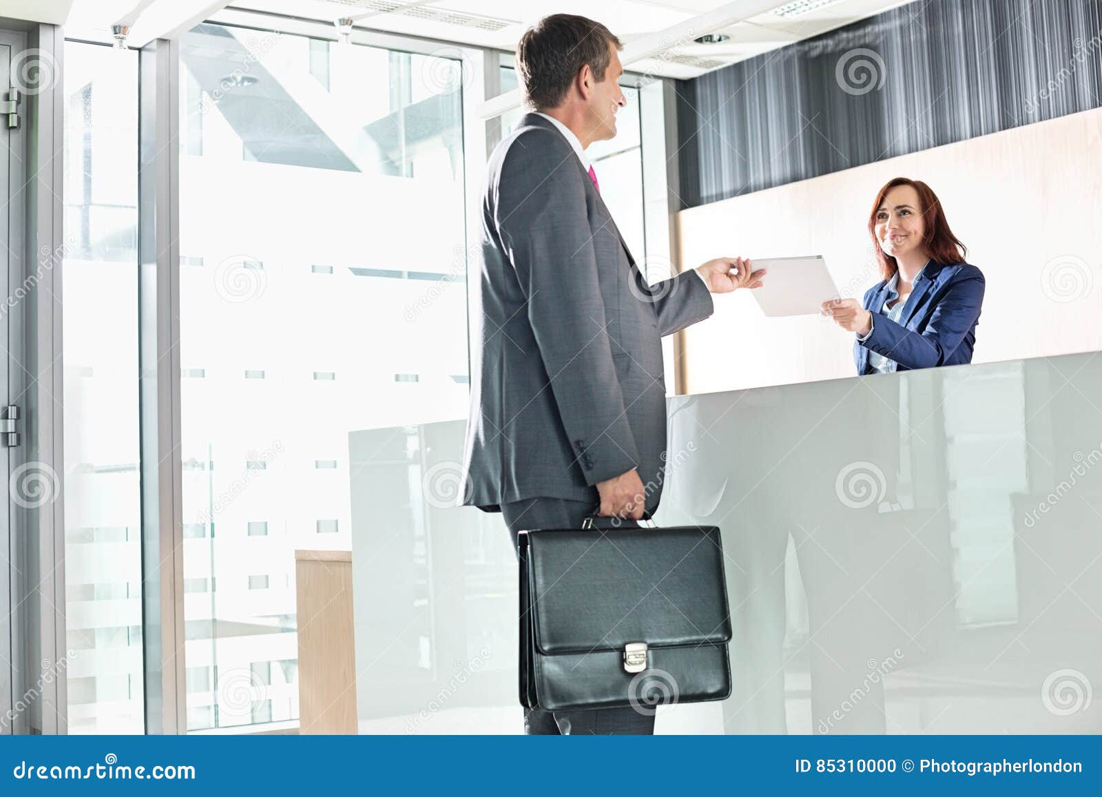Businessman Receiving Document from Receptionist in Office Stock Photo ...