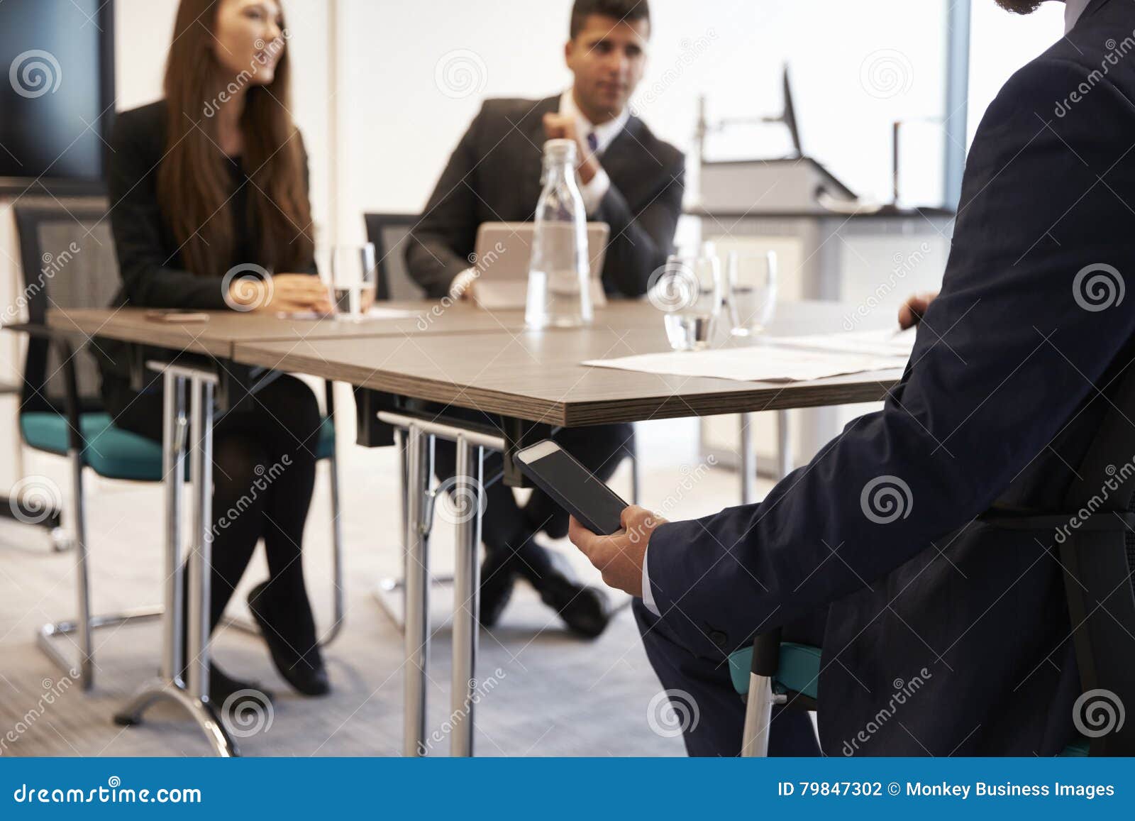 Businessman Receiving Text Message during Meeting Stock Photo - Image ...