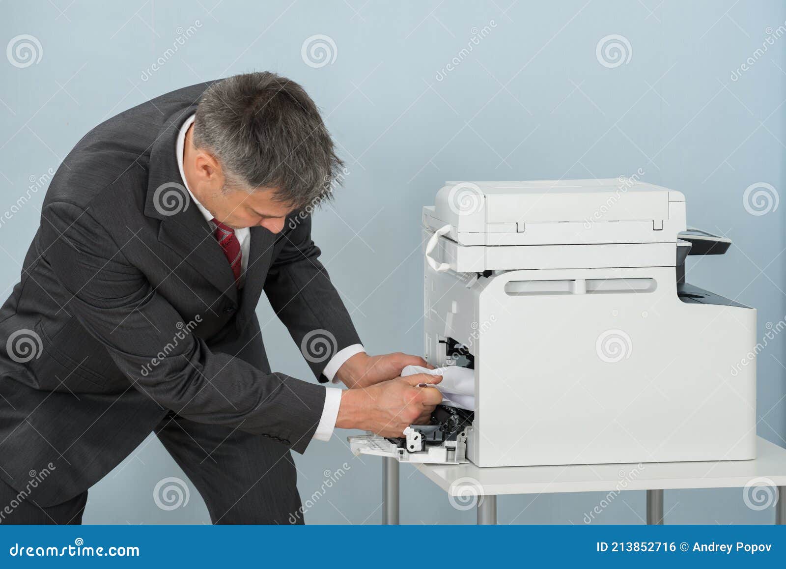 Businessman Removing Paper Stuck in Printer at Office Stock Photo ... Businessman Removing Paper Stuck in Printer at Office Stock Photo ...