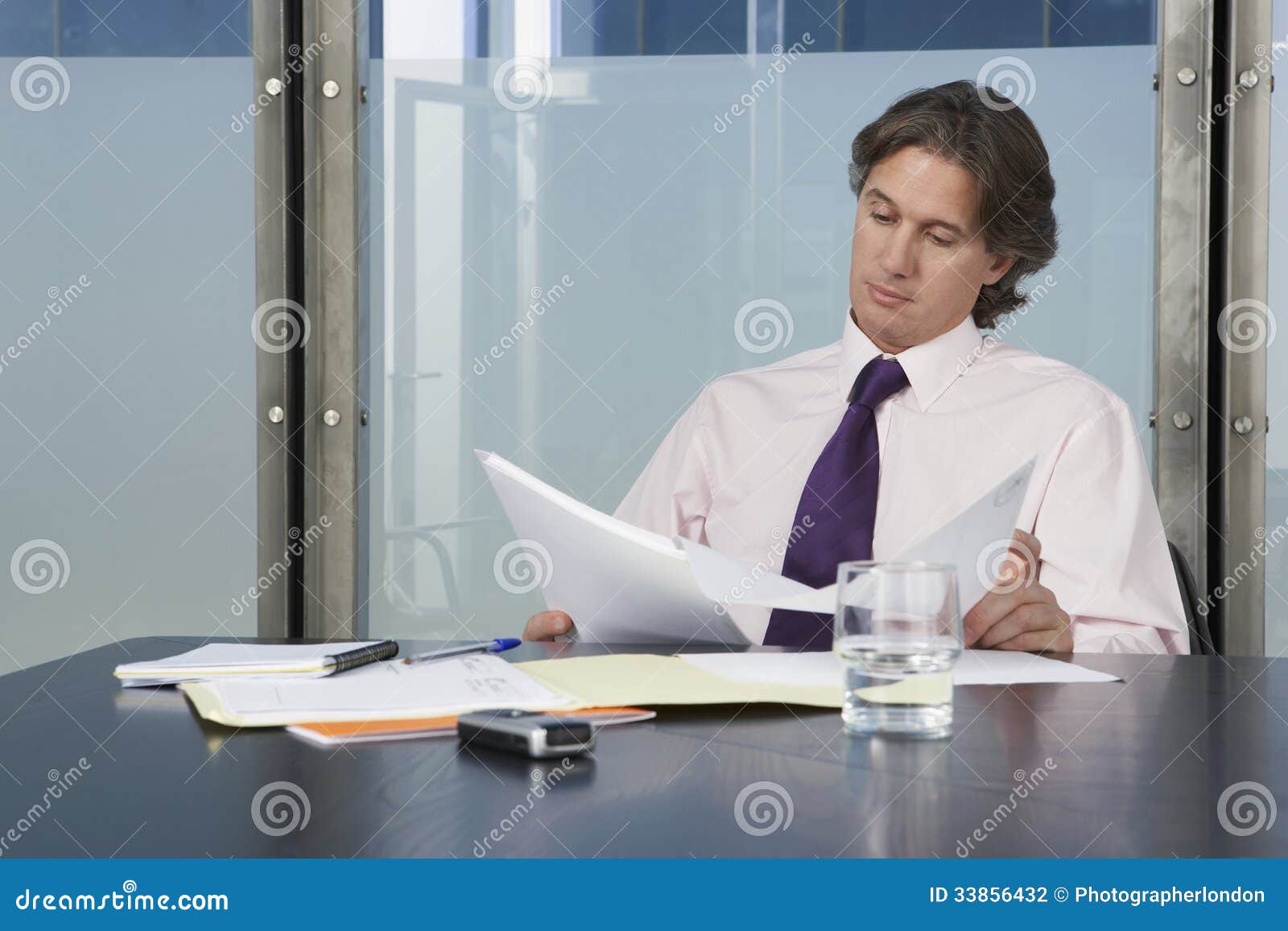 Businessman Reviewing Documents at Conference Table Stock Photo - Image ...