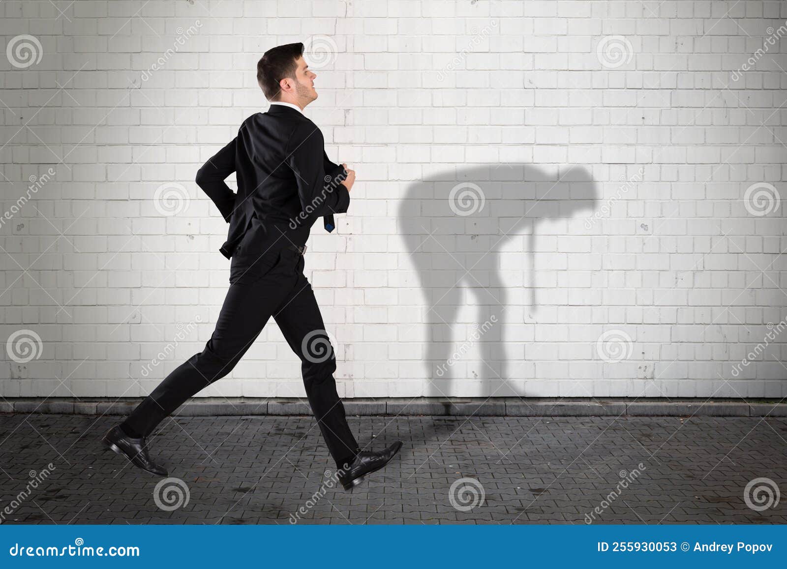 Businessman Running on Sidewalk with His Shadow on Wall Stock Image ...
