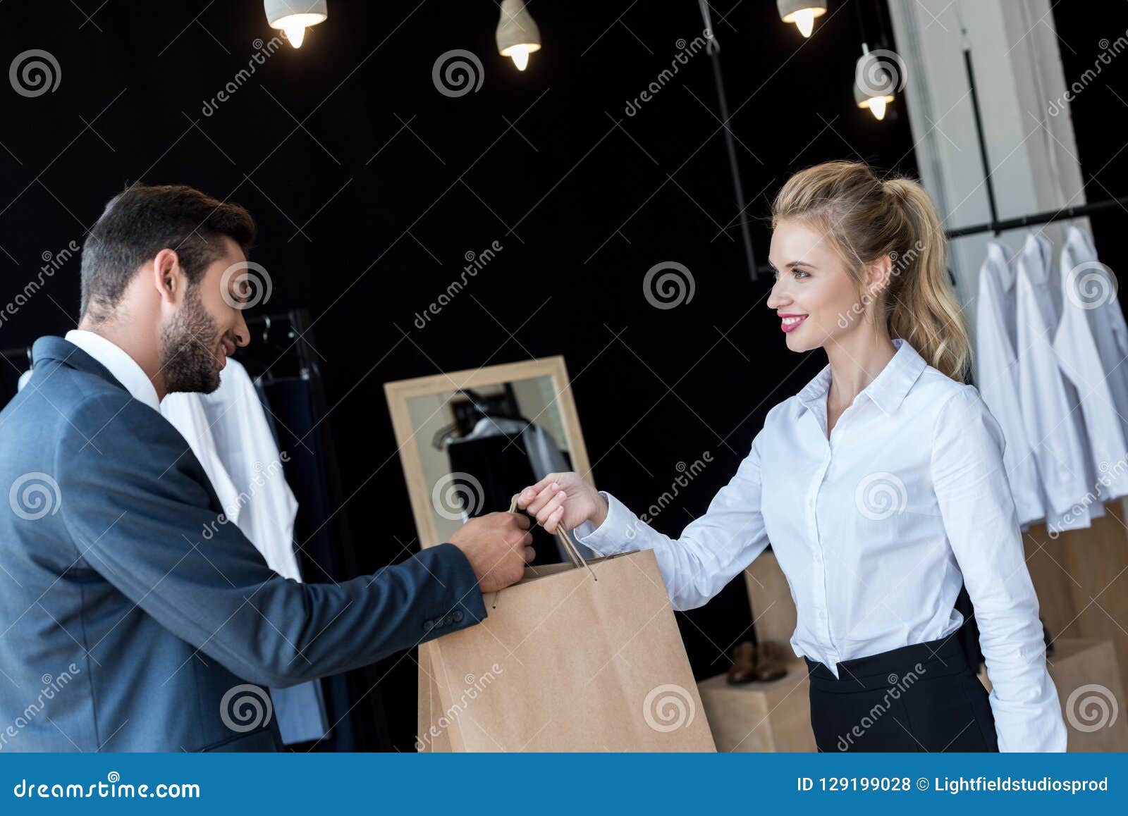 Side View of Smiling Seller Giving Shopping Bags To Businessman Stock ... Side View of Smiling Seller Giving Shopping Bags To Businessman Stock ...