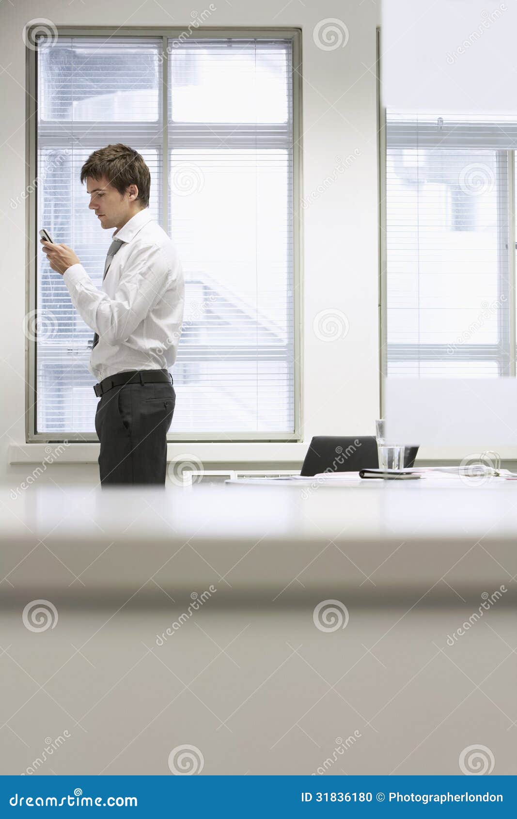 Businessman Sending Text Message by Desk Stock Photo - Image of ...