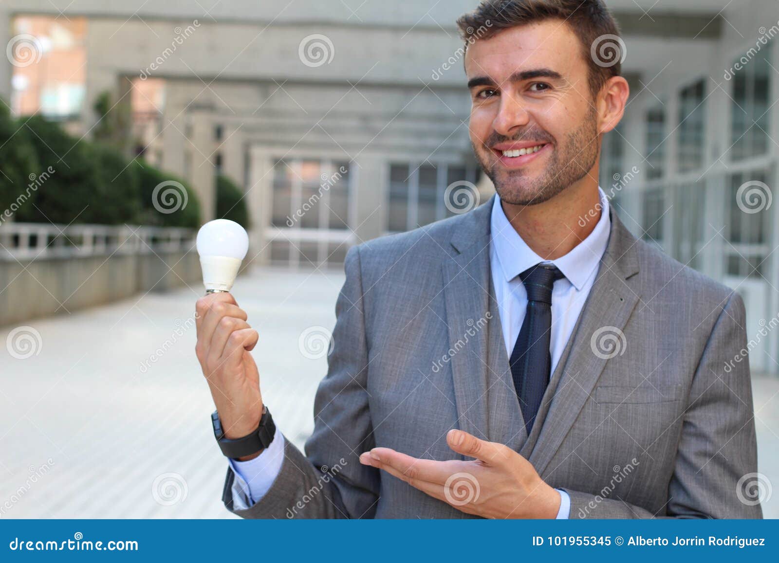Businessman Showing Light Bulb in Office Building Stock Image - Image ...