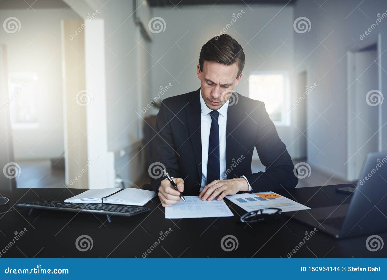 Businessman Signing a Document while Working at His Office Desk Stock ...