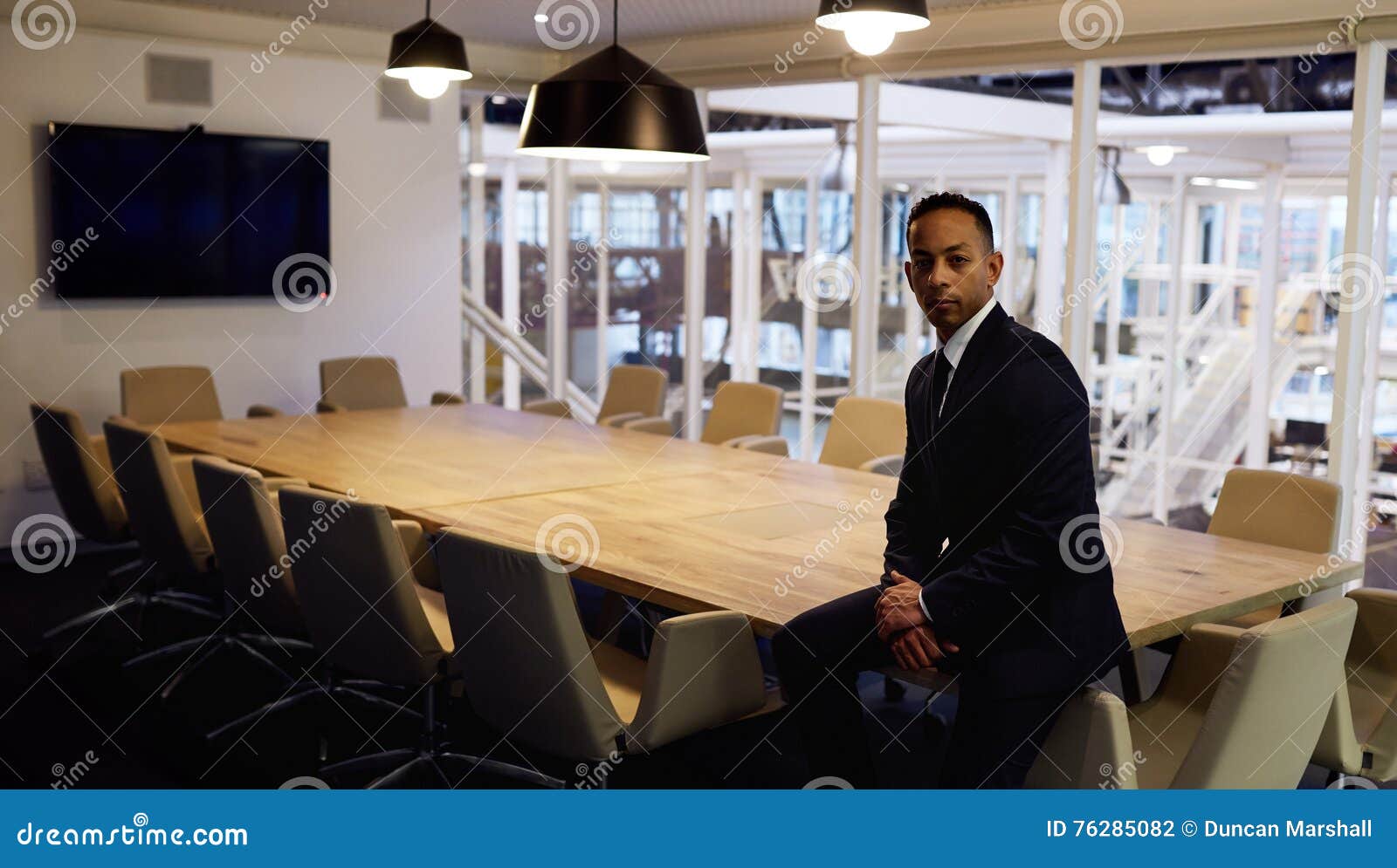 Businessman Sitting on Conference Table Alone in Empty Office Stock ...