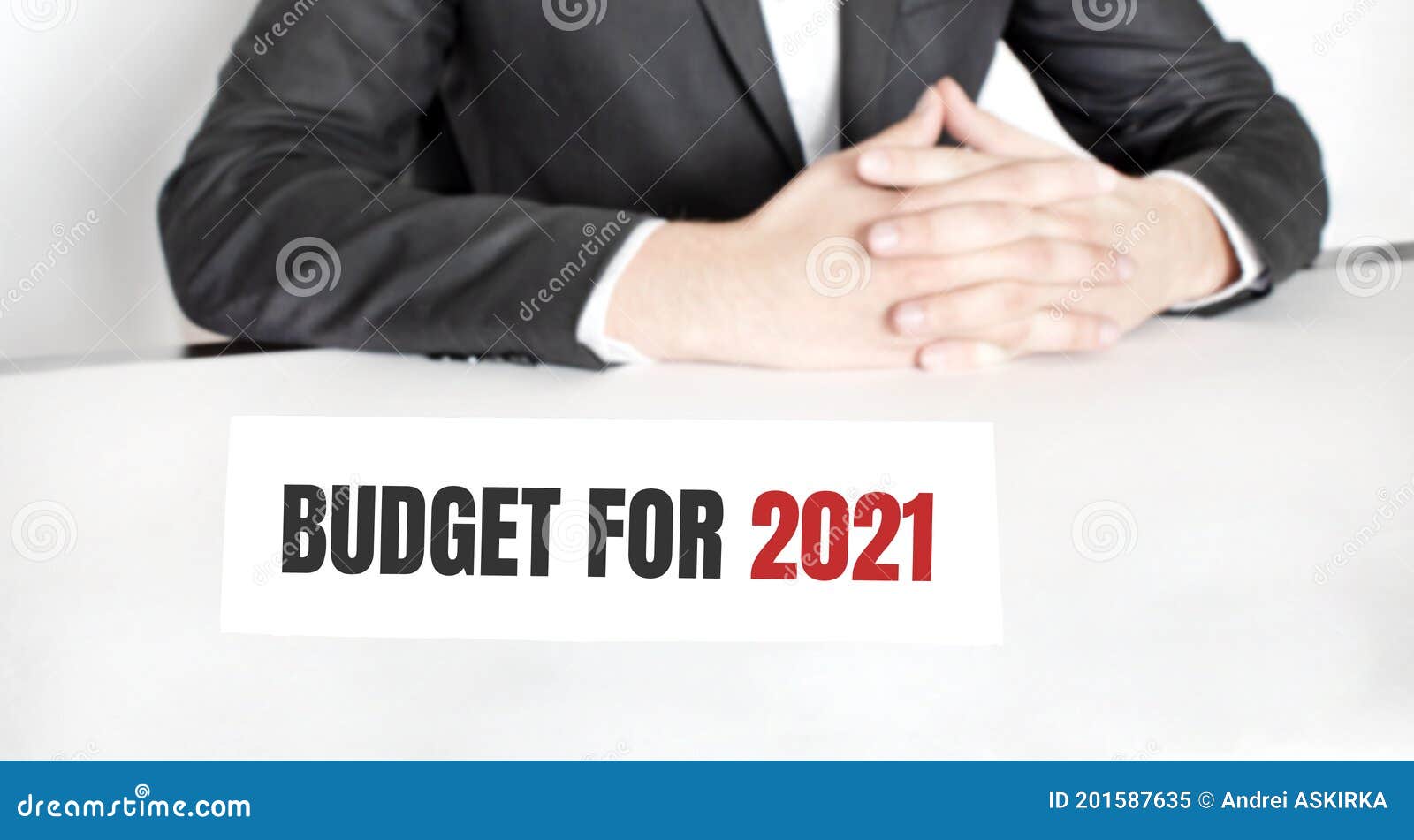 Businessman Sitting at the Table and Signboard with Text Budget for ...