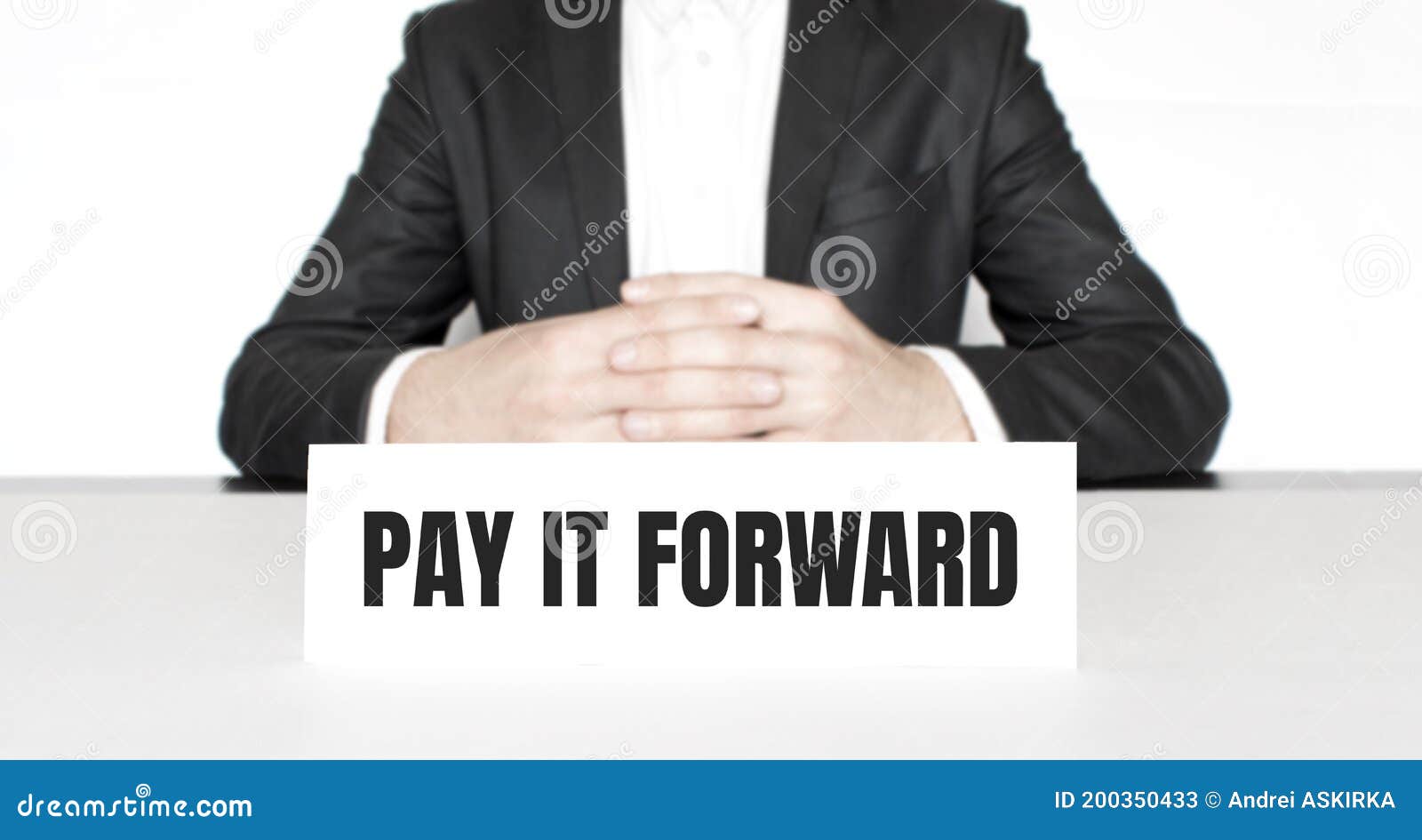 Businessman Sitting at the Table and Signboard with Text PAY it FORWARD ...