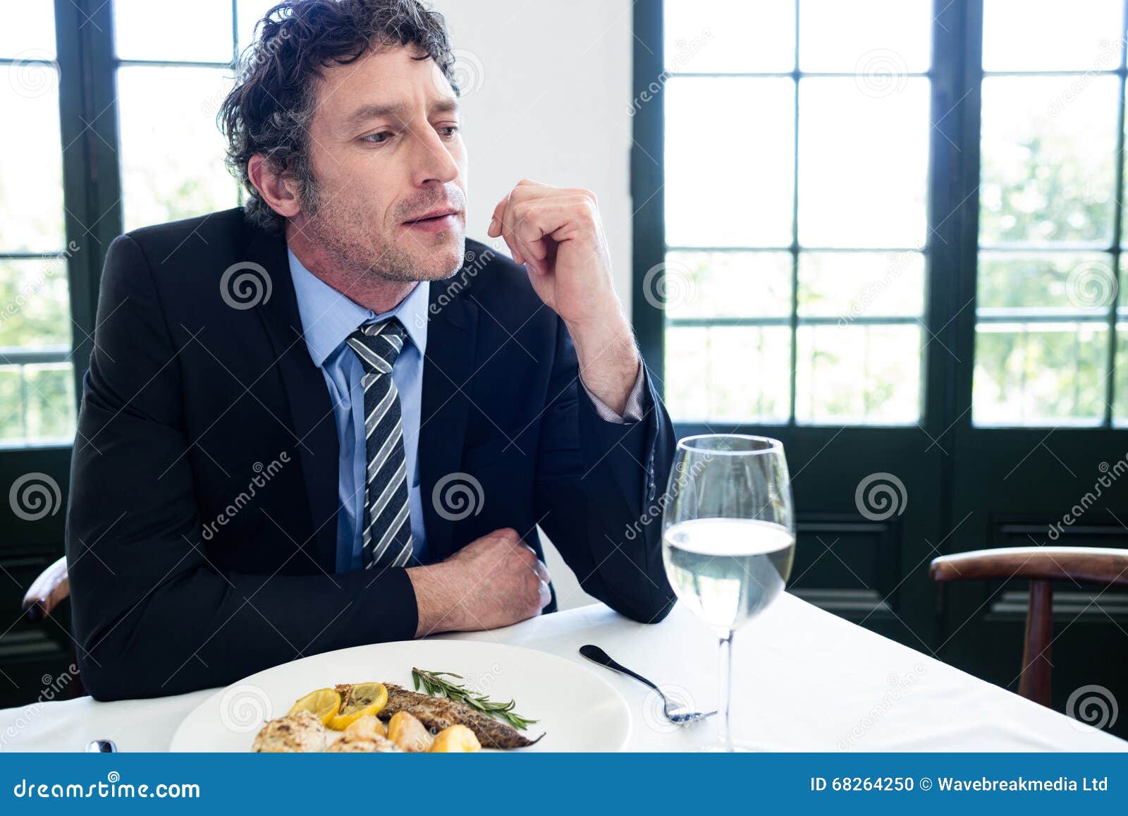 Businessman Sitting at Table Stock Photo - Image of sitting, away: 68264250