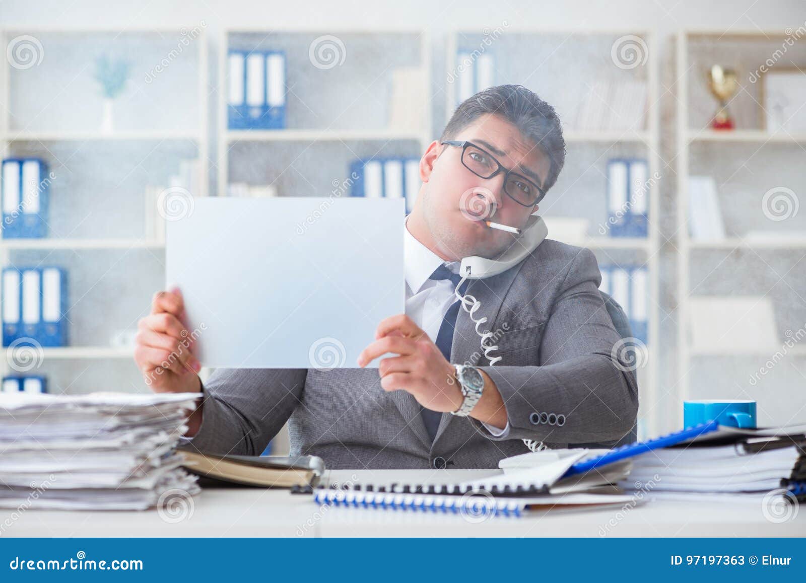 Businessman Smoking at Work in Office Holding a Blank Message Bo Stock ...
