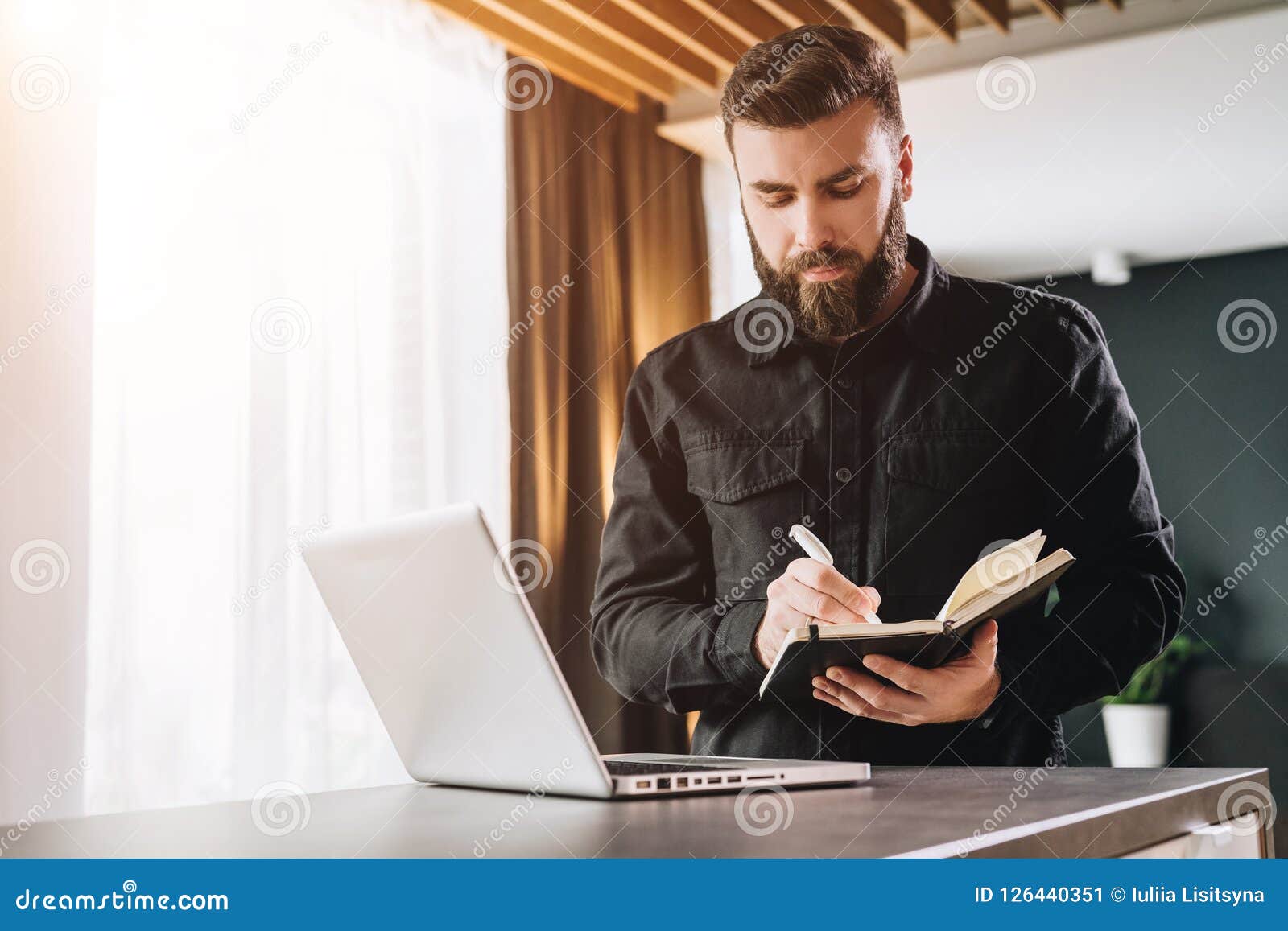 Businessman is Standing by Computer, Making Notes in Notebook. Man ...
