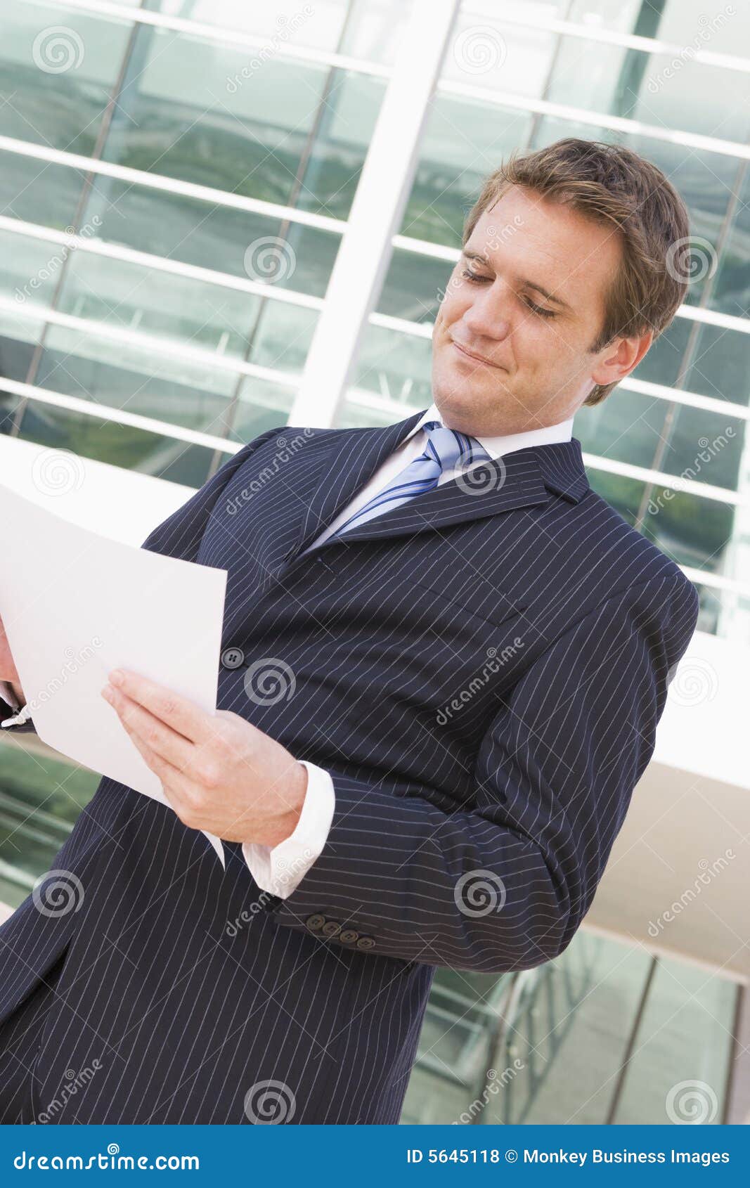 Businessman Standing Outdoors Looking at Paperwork Stock Photo - Image ...